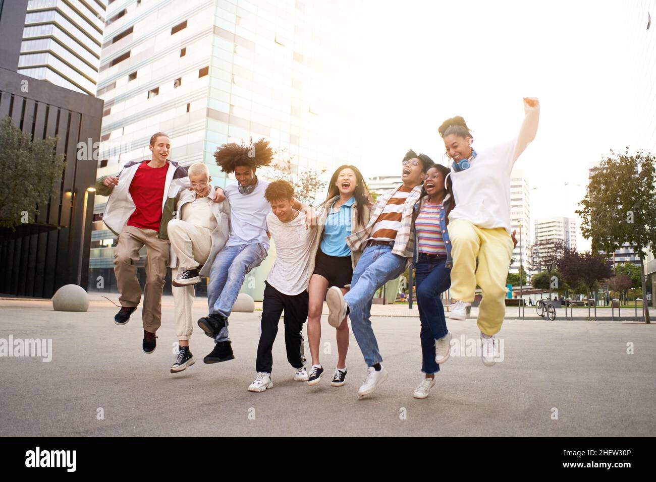 Carefree happy friends jumping in the street. Multiethnic group of ...