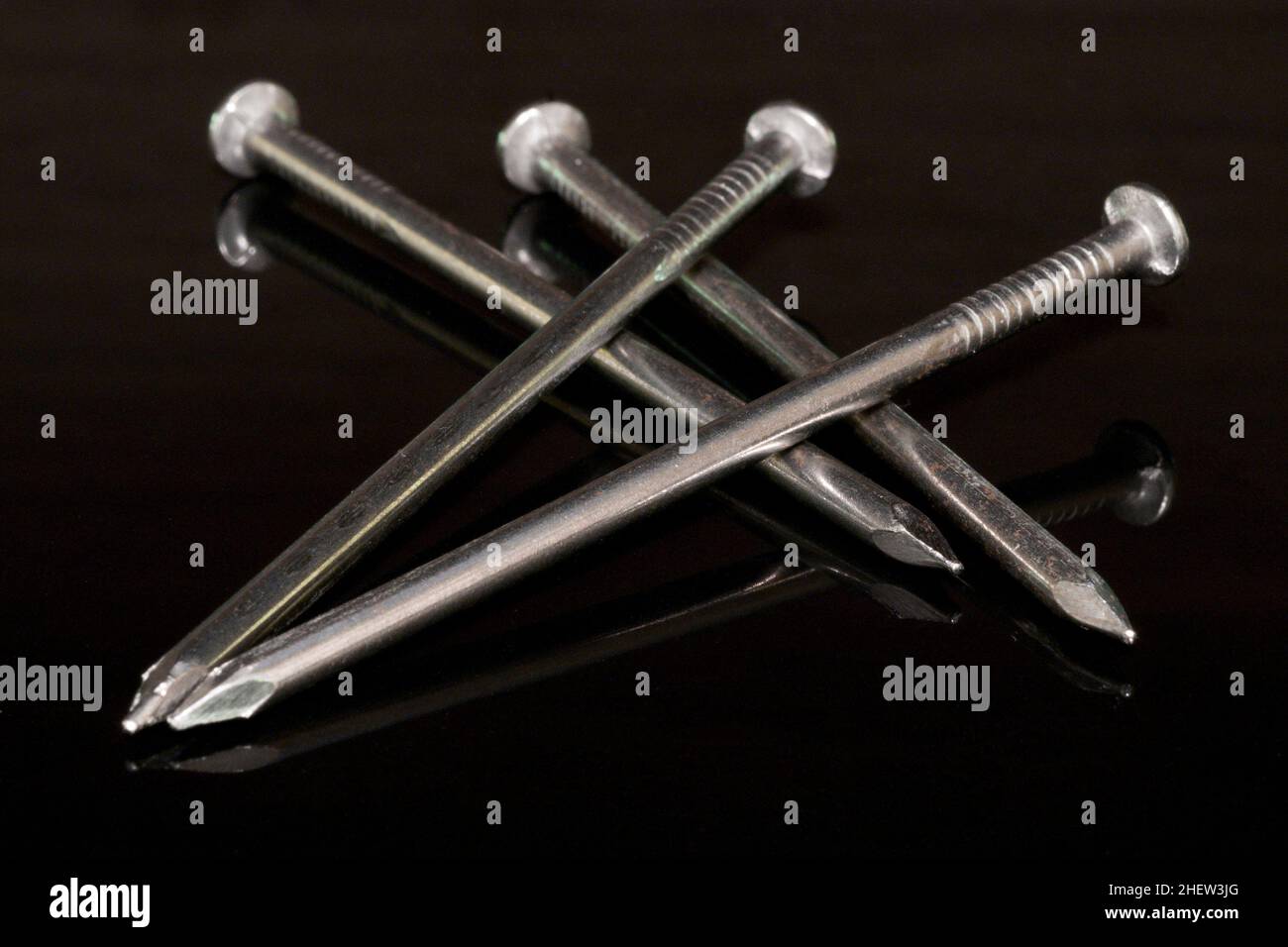 70mm steel nails on black background Stock Photo - Alamy