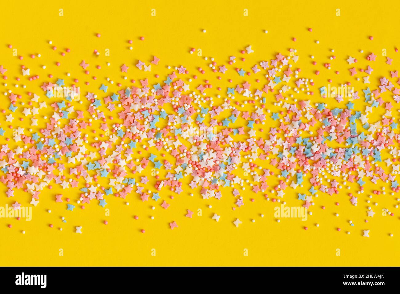 Colorful sprinkles on a yellow background Stock Photo - Alamy