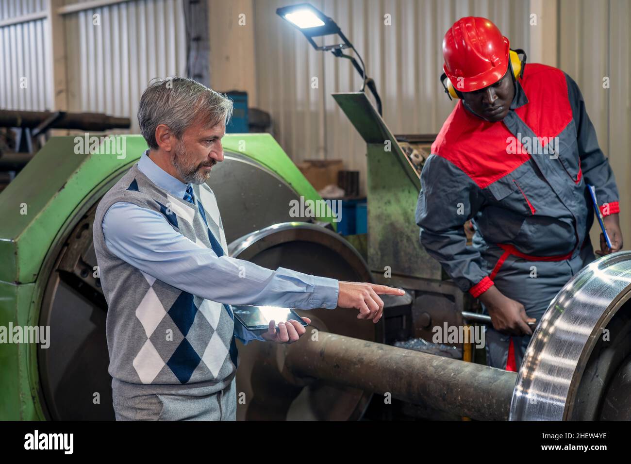 Multiracial Industrial Co Workers Standing And Talking Next To Lathe ...