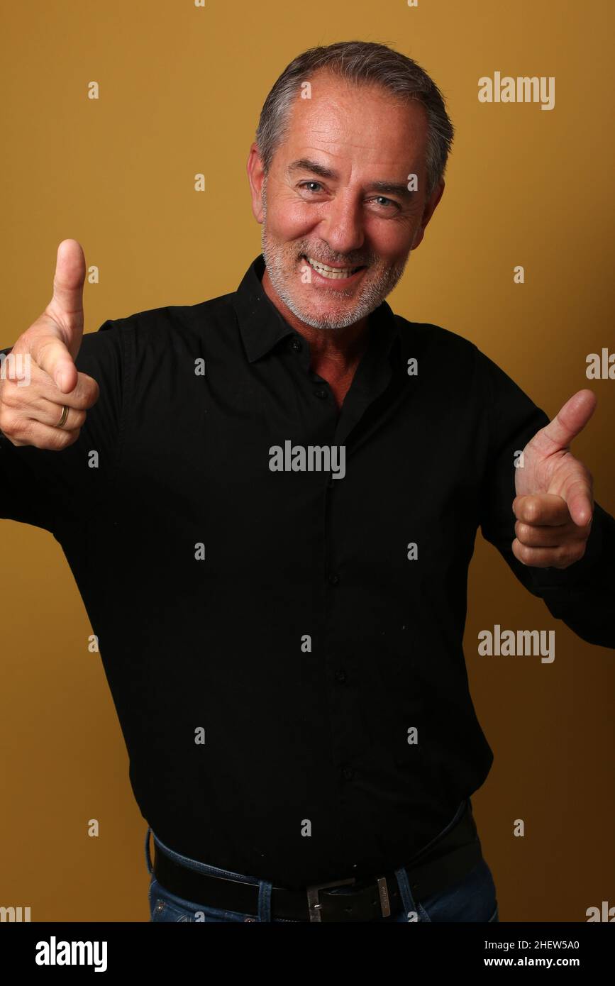 Portrait of a beautiful happy man in front of a colored background ...