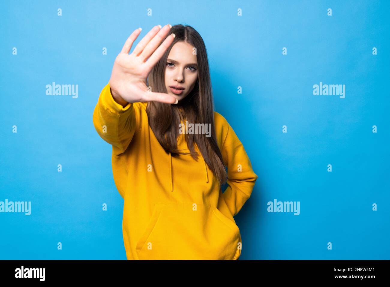 Caucasian woman over blue background doing stop sing with palm of the ...