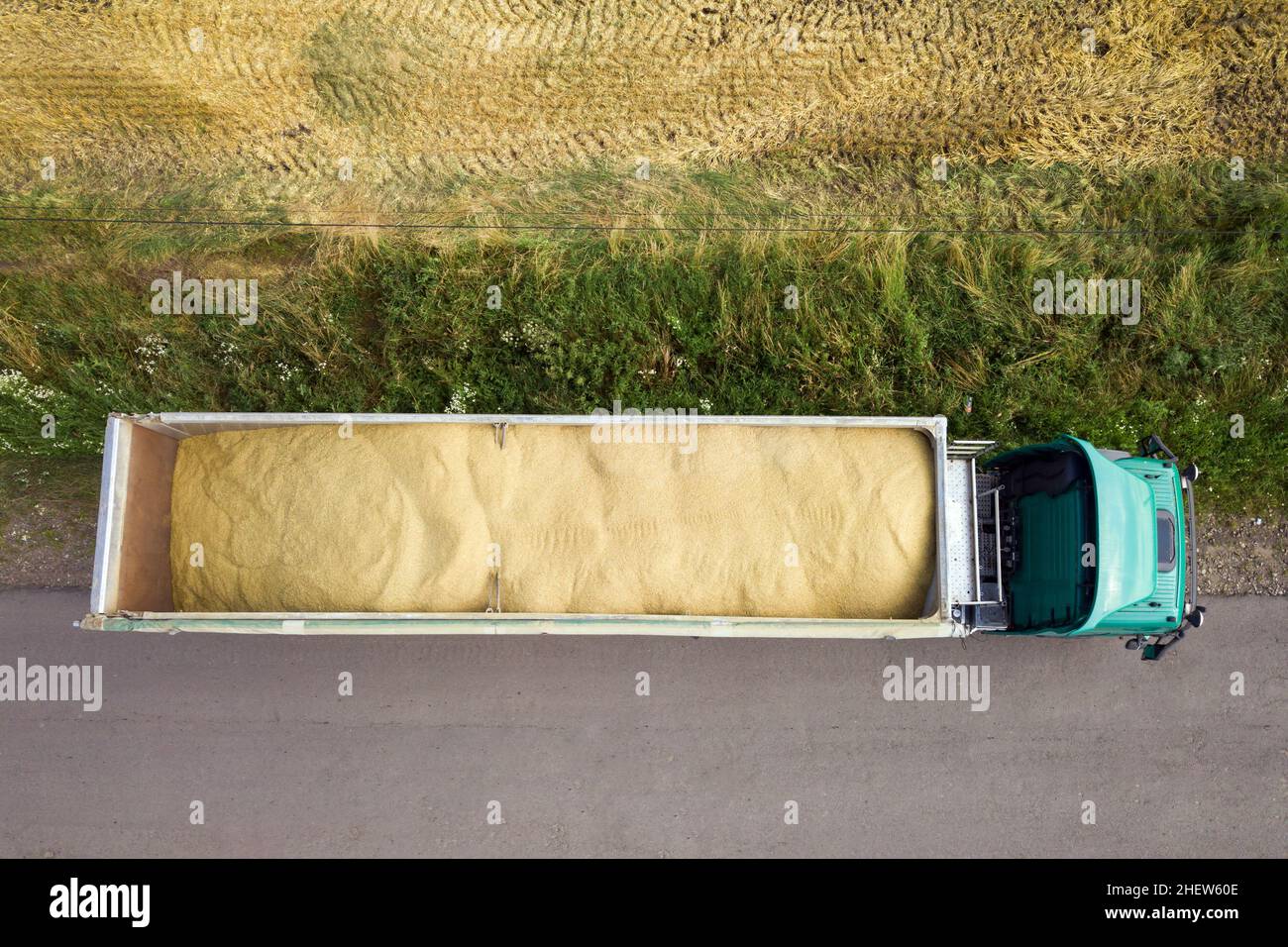 Aerial view of cargo truck driving on dirt road between agricultural ...