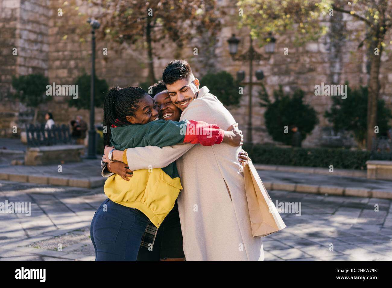 Three friends hugging each other emotionally outdoors Stock Photo - Alamy