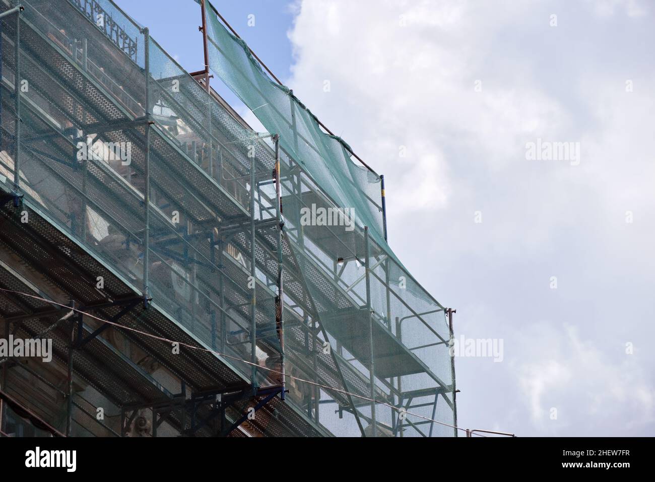 Building facade under renovation works with construction scaffolding ...