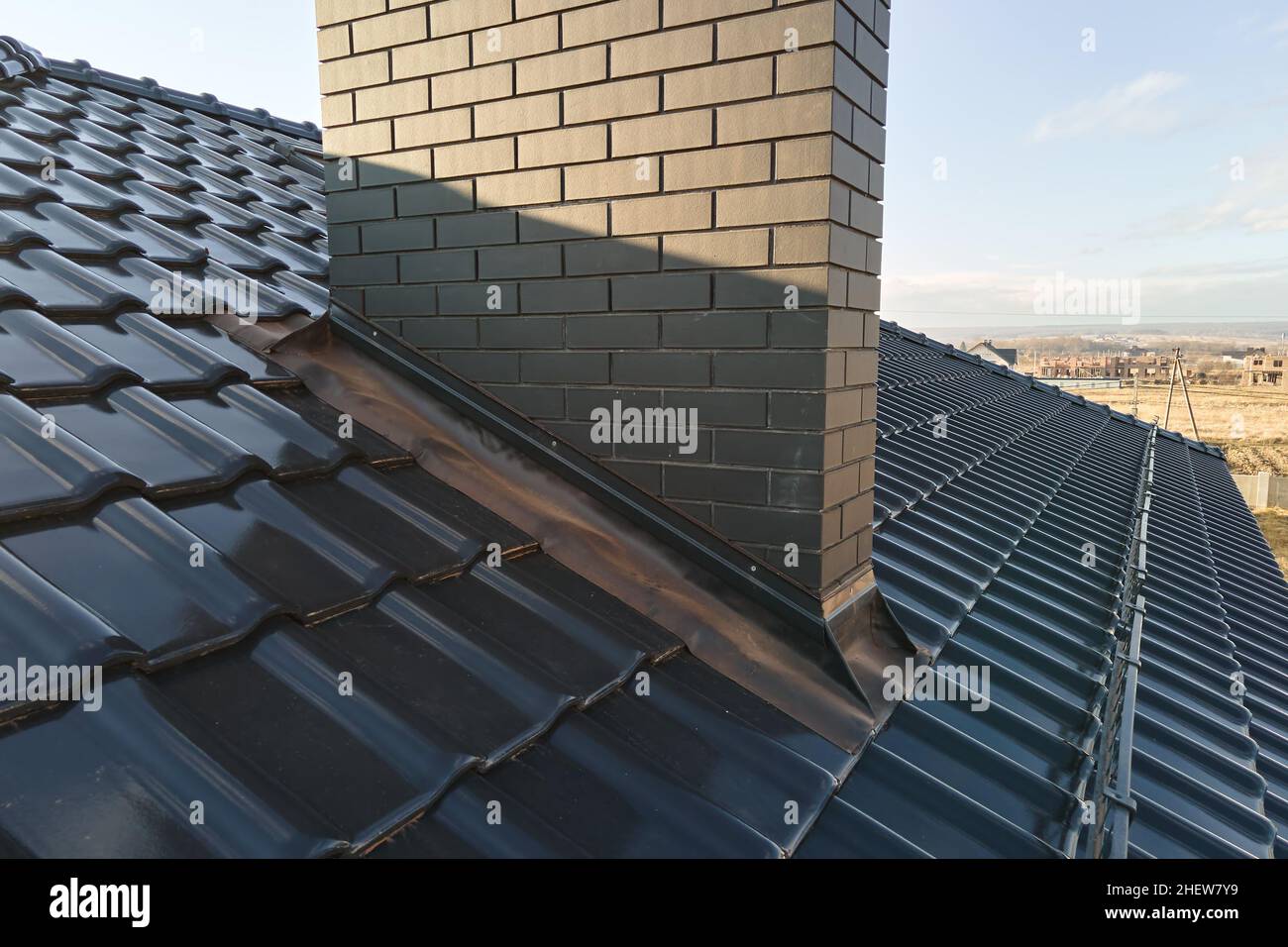 Closeup of brick chimney on house roof top covered with ceramic ...