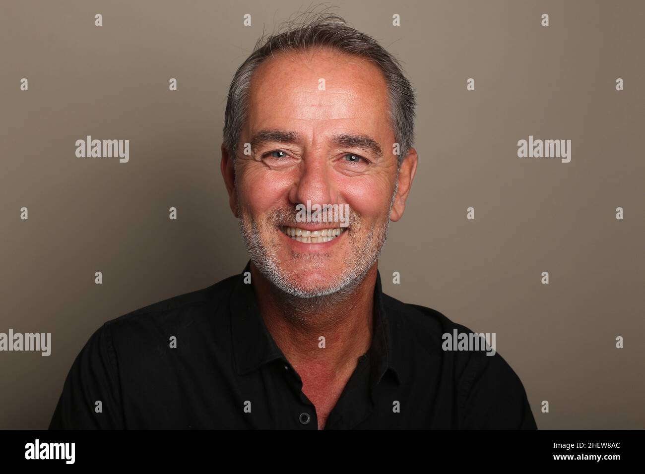 Portrait of a beautiful happy man in front of a colored background ...