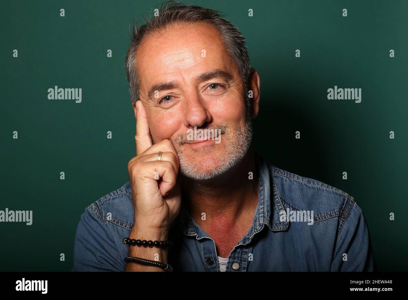Portrait of a beautiful happy man in front of a colored background ...
