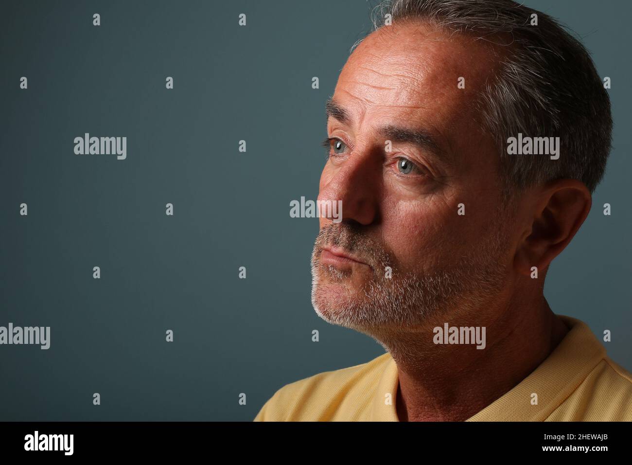 Portrait of a beautiful happy man in front of a colored background ...