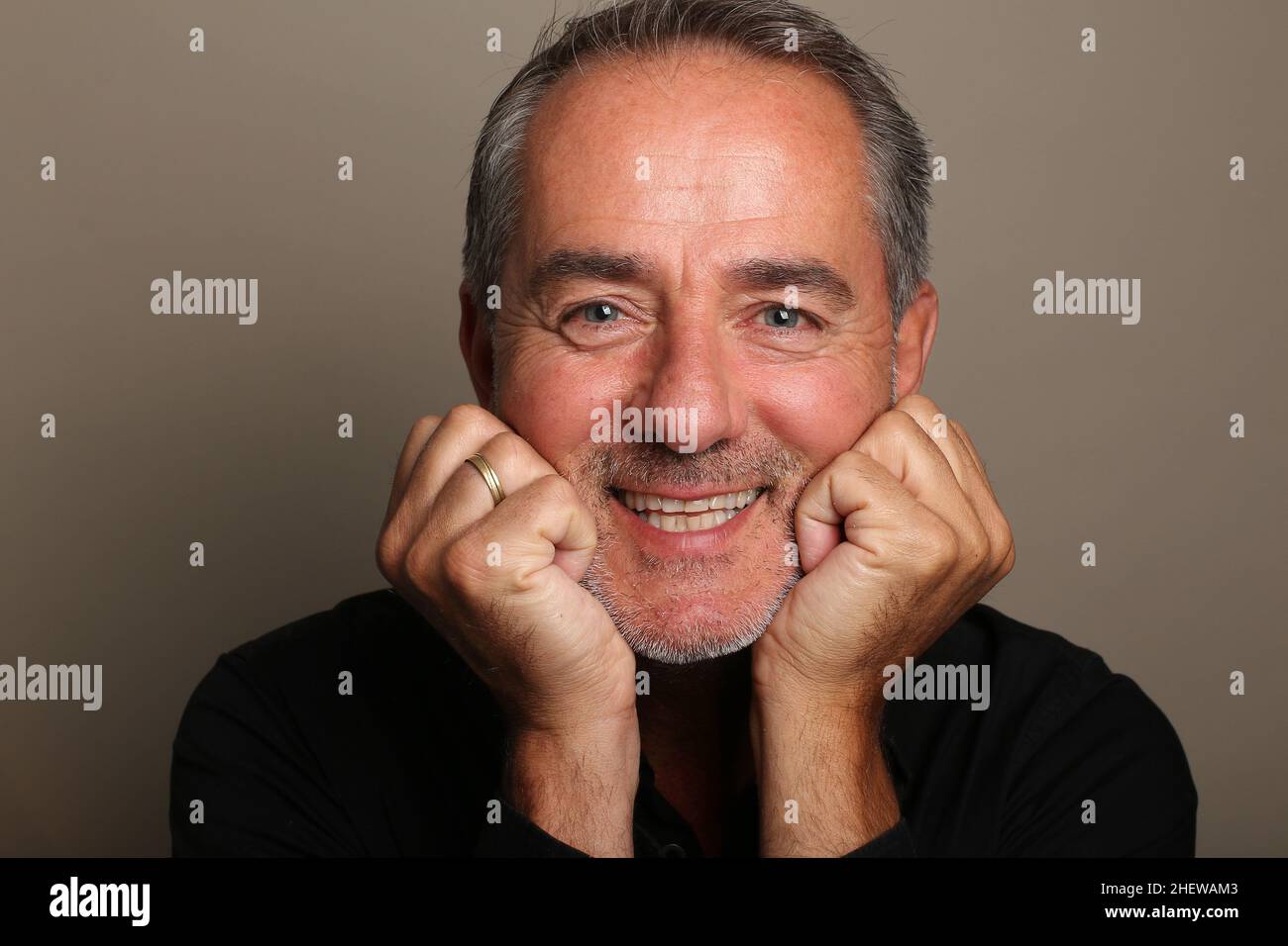 Portrait of a beautiful happy man in front of a colored background ...