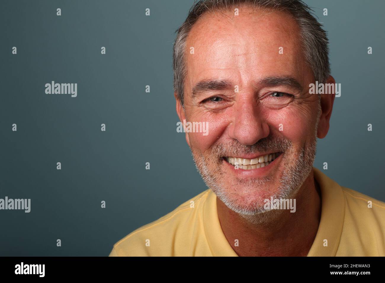 Portrait of a beautiful happy man in front of a colored background ...