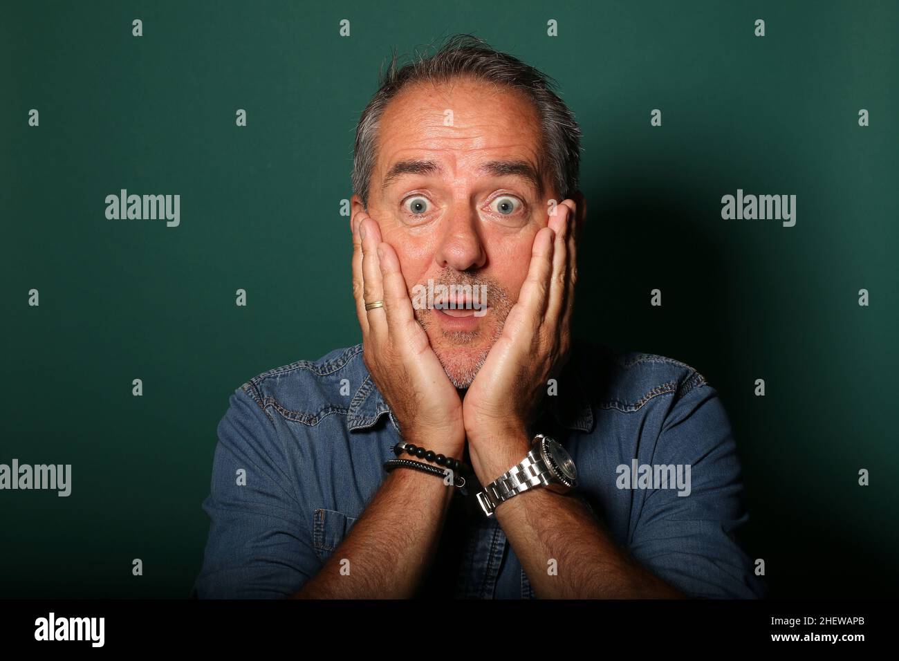 Portrait of a beautiful happy man in front of a colored background ...