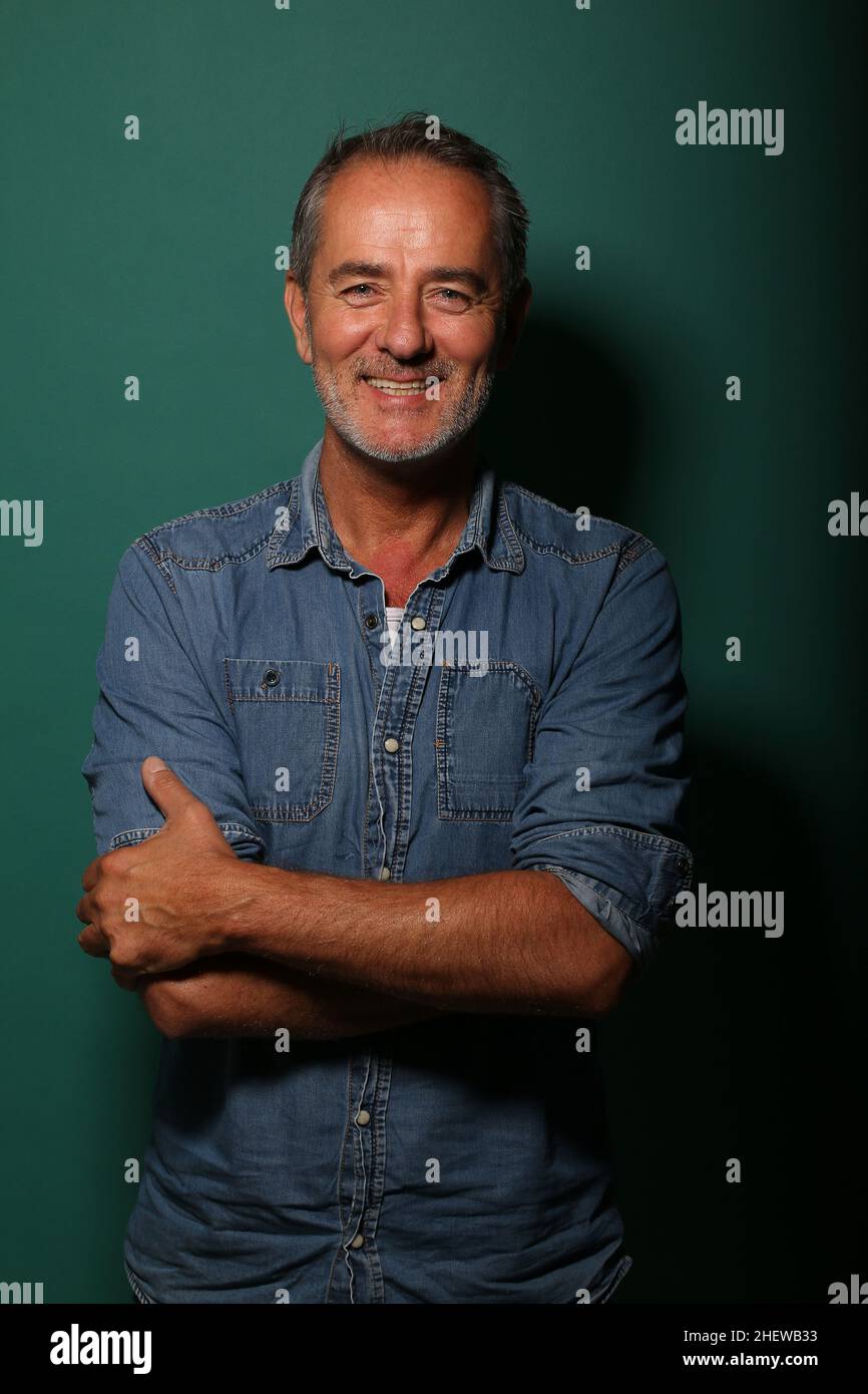 Portrait of a beautiful happy man in front of a colored background ...