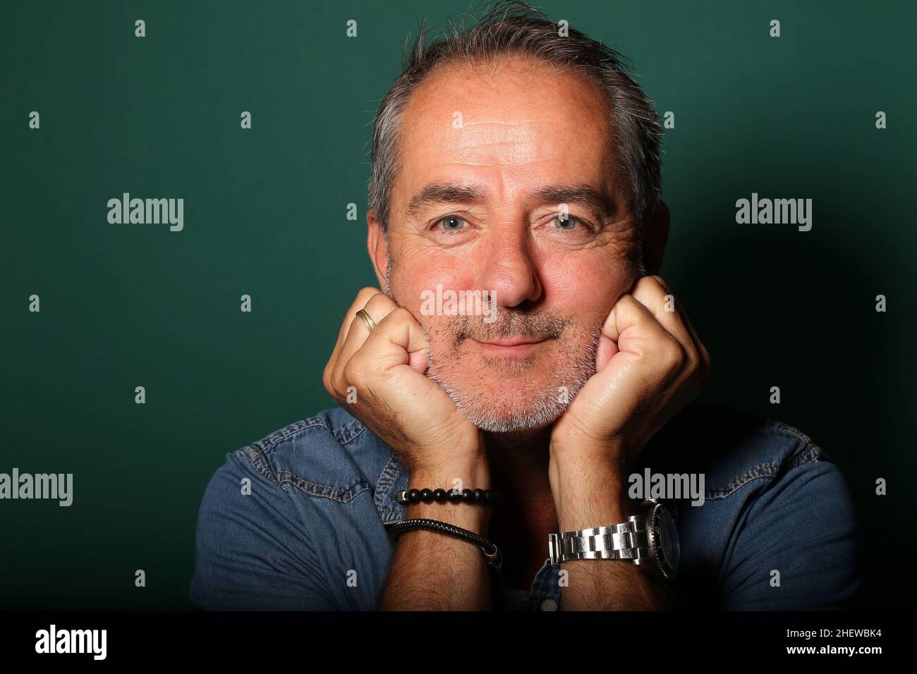 Portrait of a beautiful happy man in front of a colored background ...