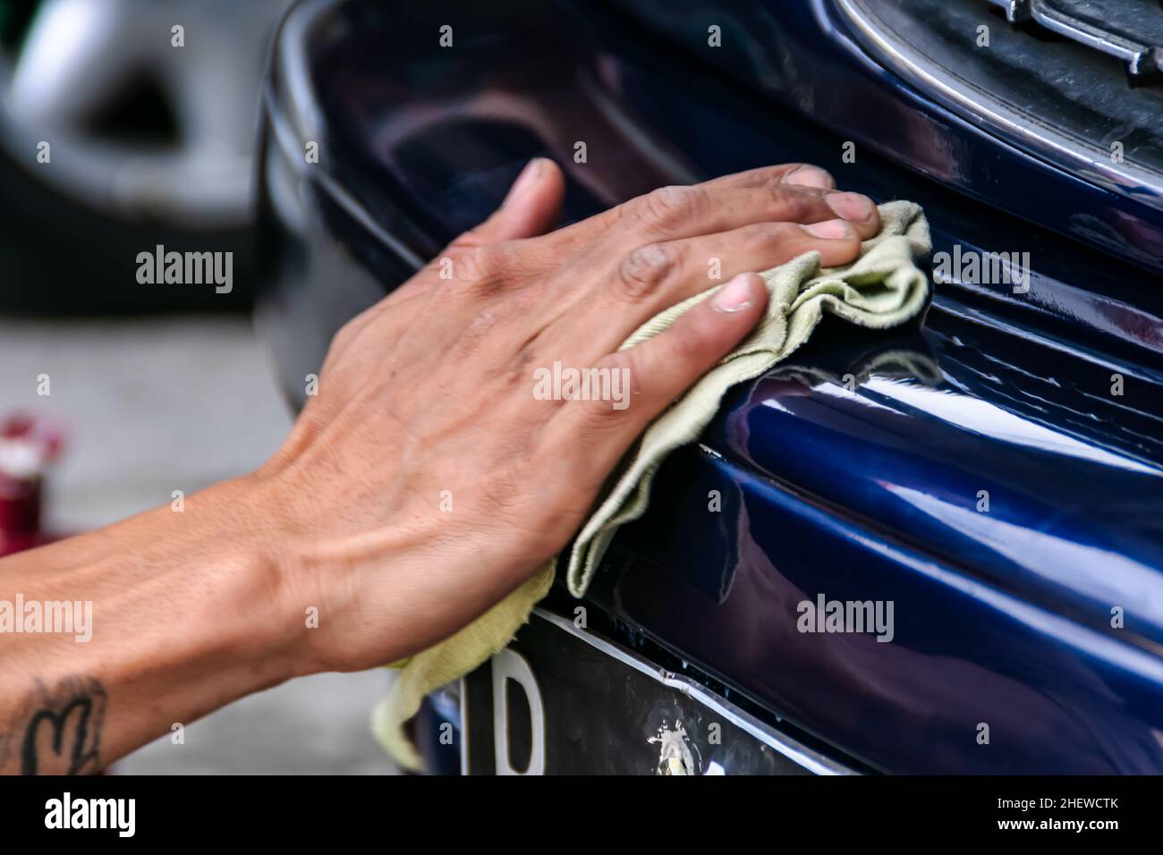 Man hand polish a blue car exterior with duster to get clean , shine ...