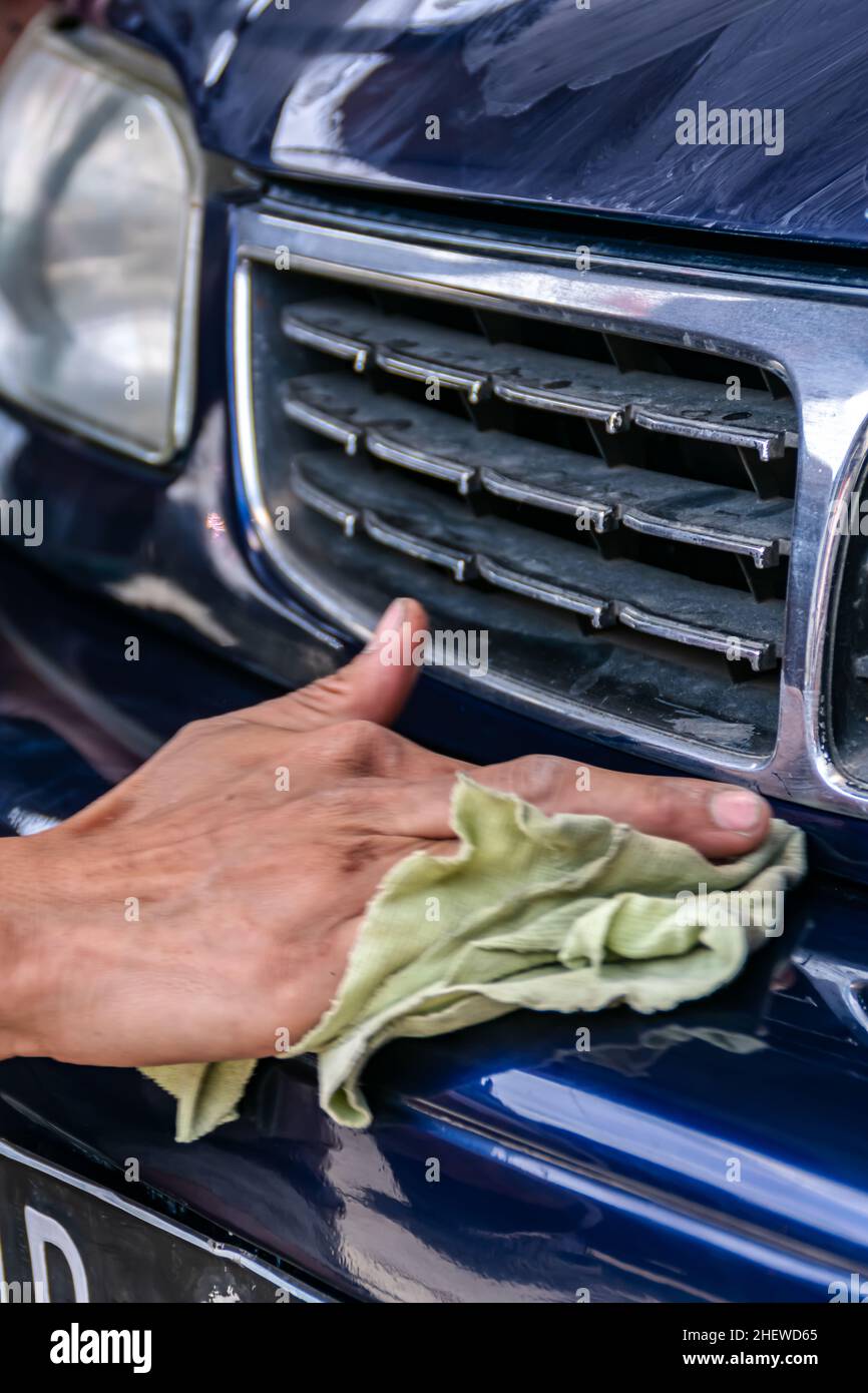 Man hand polish a blue car exterior with duster to get clean , shine ...