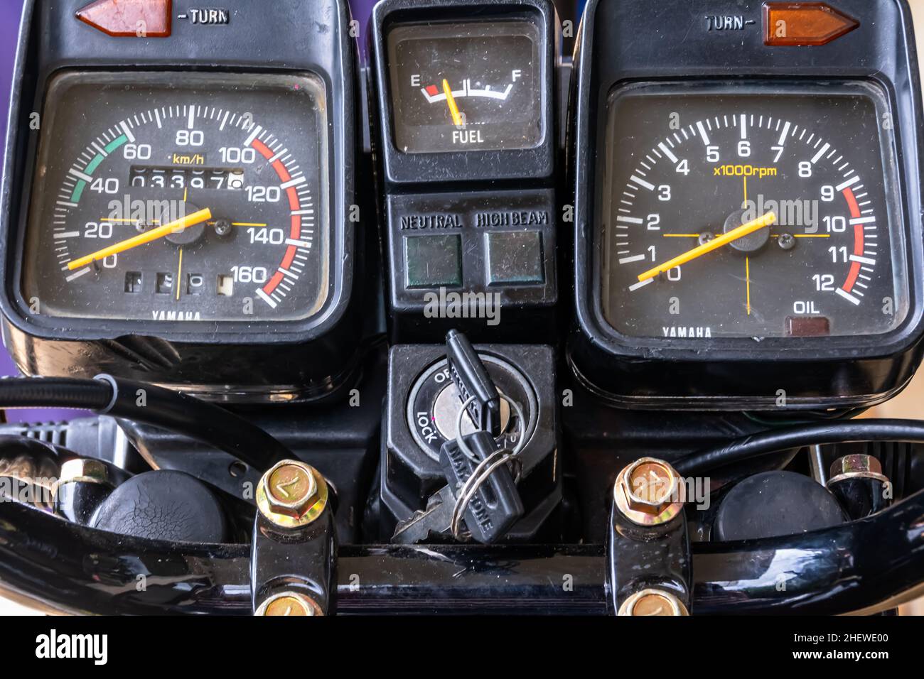 Black vintage analog motorcycle dashboard instrument with a key hanging ...