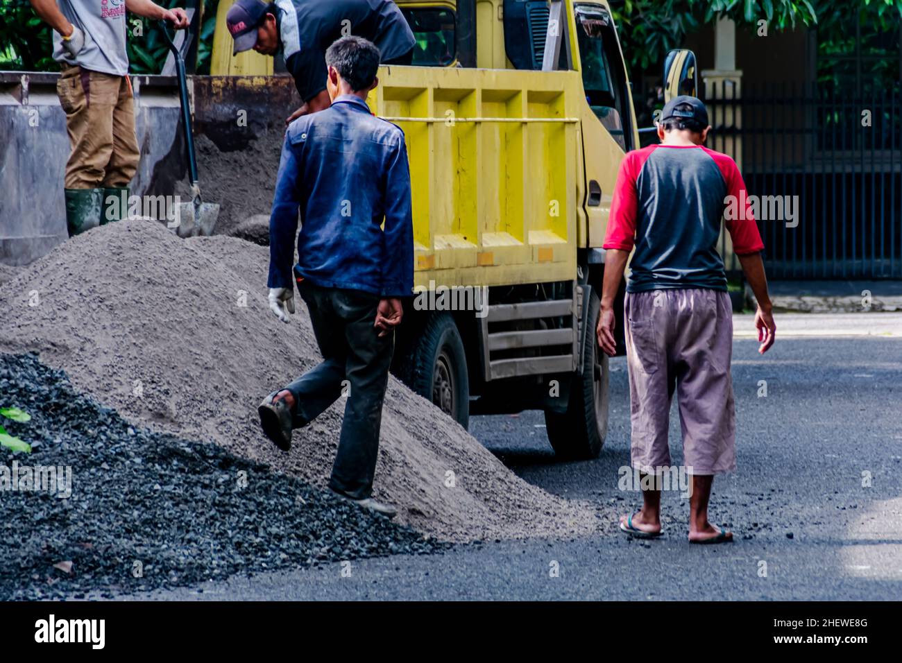 Mans working dropping the sands and split stones with shovel from the ...