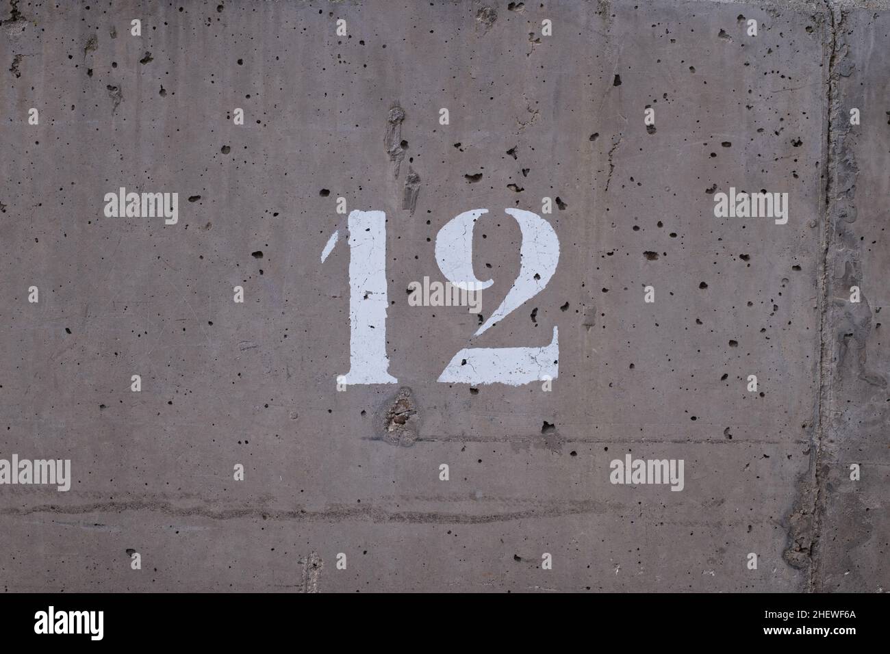 number 12 printed on a concrete wall full of small holes Stock Photo ...