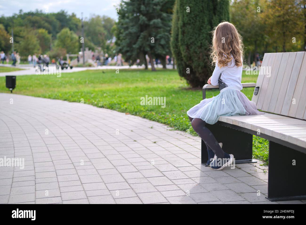 Portrait of pretty child girl sitting on park bench outdoors Stock ...