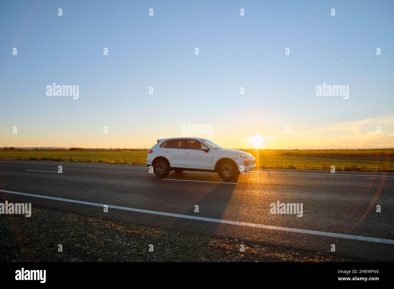 SUV car driving fast on intercity road at sunset. Highway traffic in ...