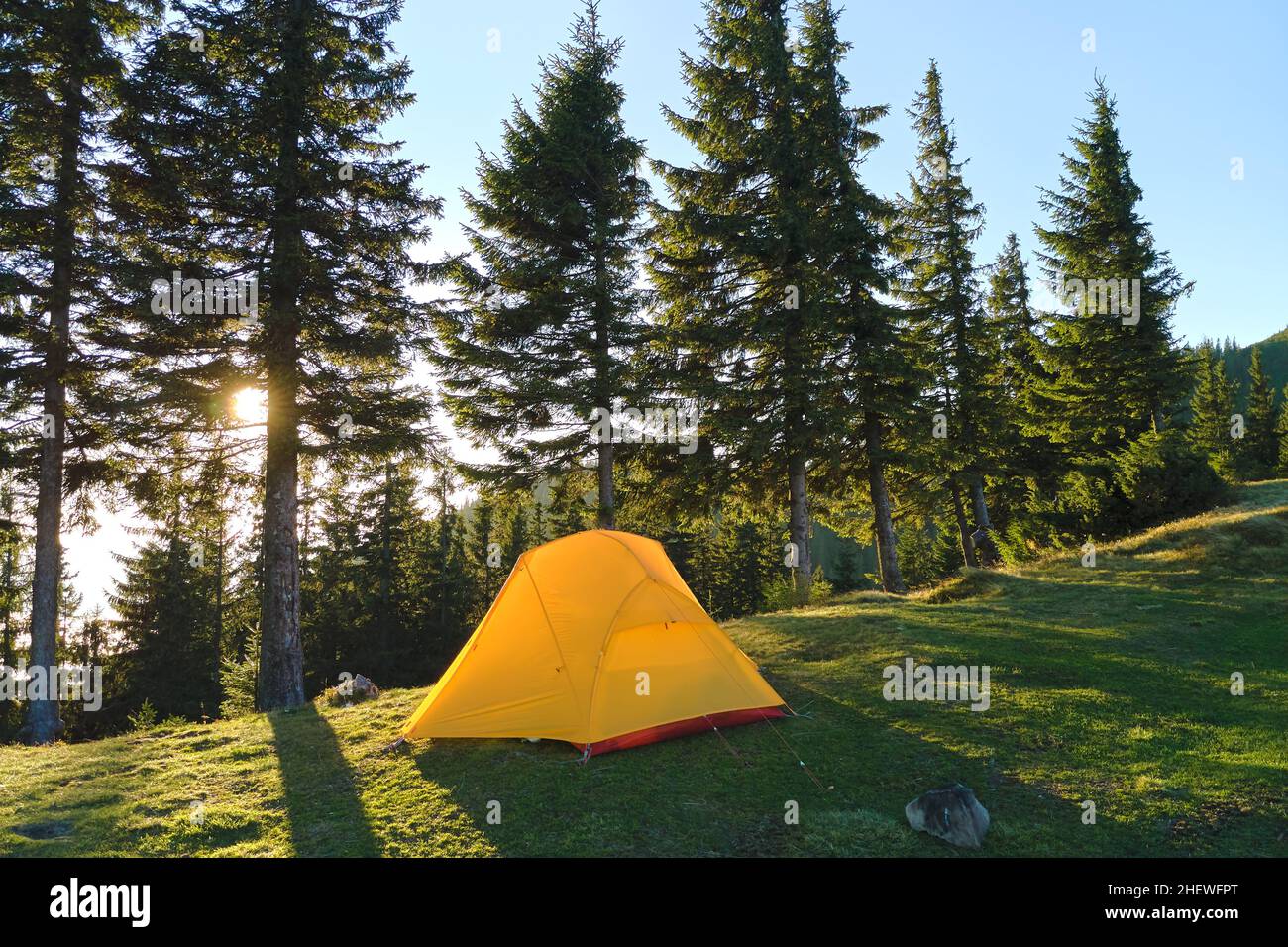 Tourist camping tent on mountain campsite at bright sunny evening ...