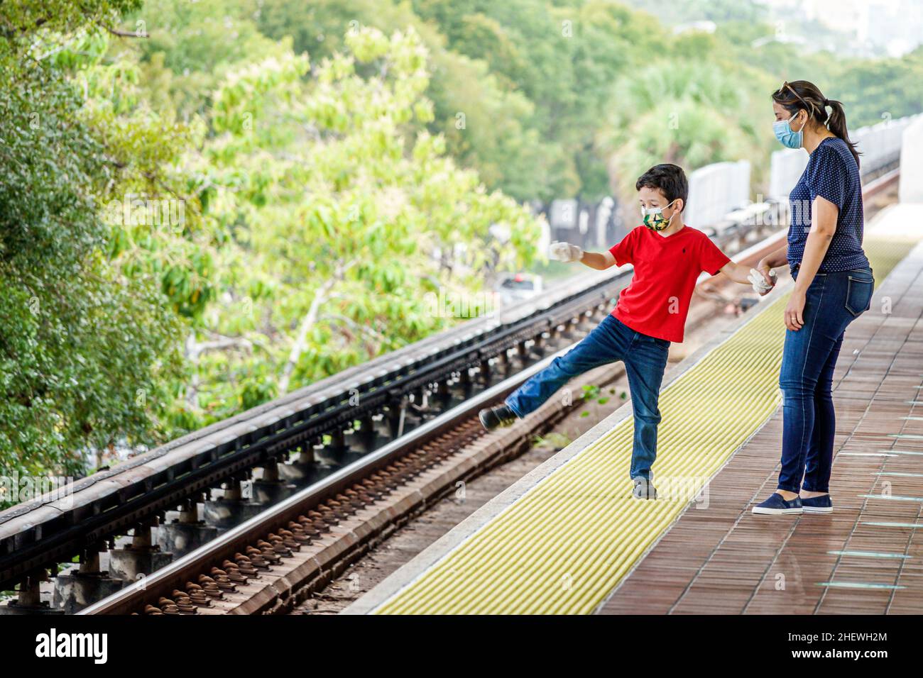 Hispanic mother woman restraining boy child son holding hand hi-res ...