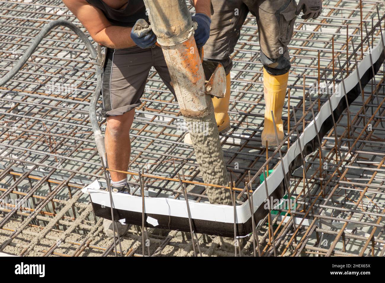 worker fill in cement in the construction of the concrete foundation ...