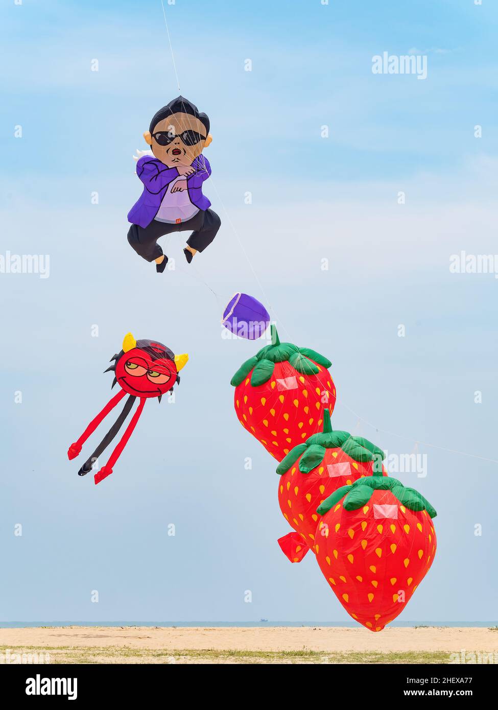 Inflated, soft show kites shaped as strawberries, a friendly devil and ...