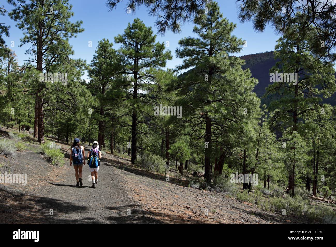 Two female hikers walking the Lenox Crater hiking trail in the Sunset ...