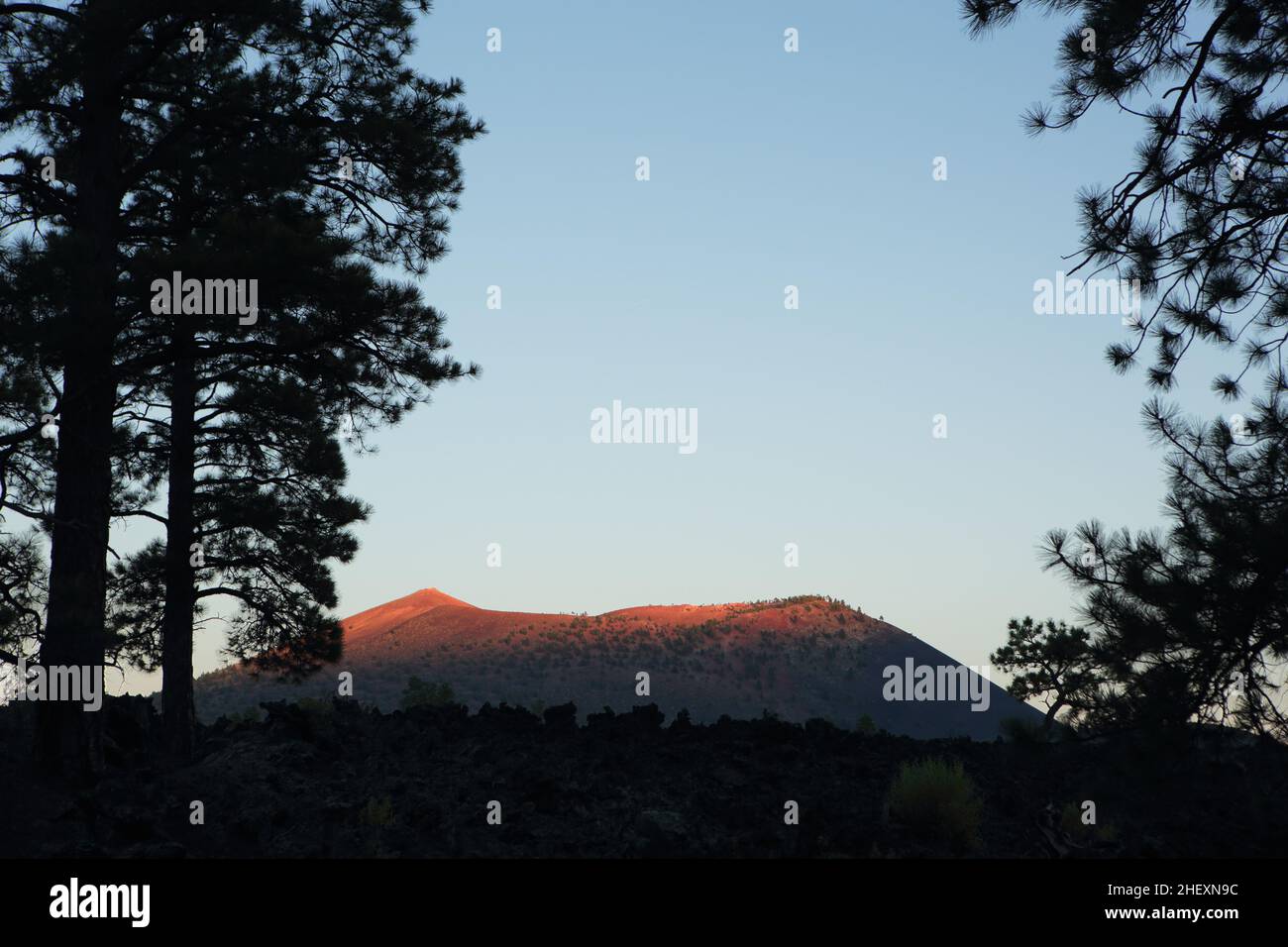 View of the Sunset Crater cinder cone volcano as the setting sun makes ...