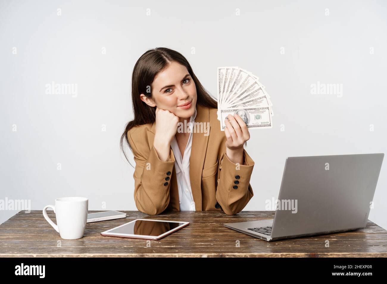 Portrait of businesswoman sitting in office with money, working and ...