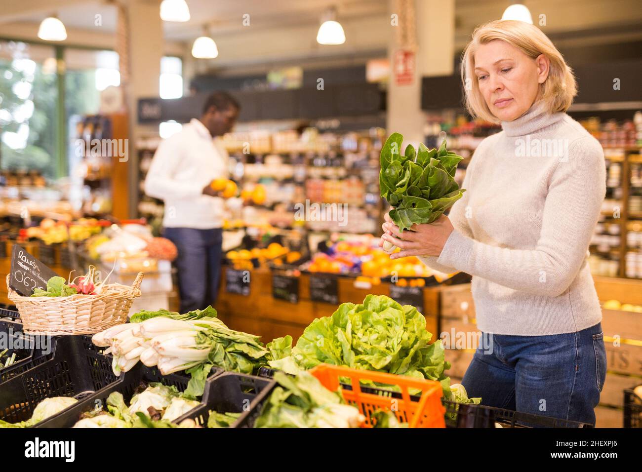 Woman choosing vegetables in food store Stock Photo - Alamy