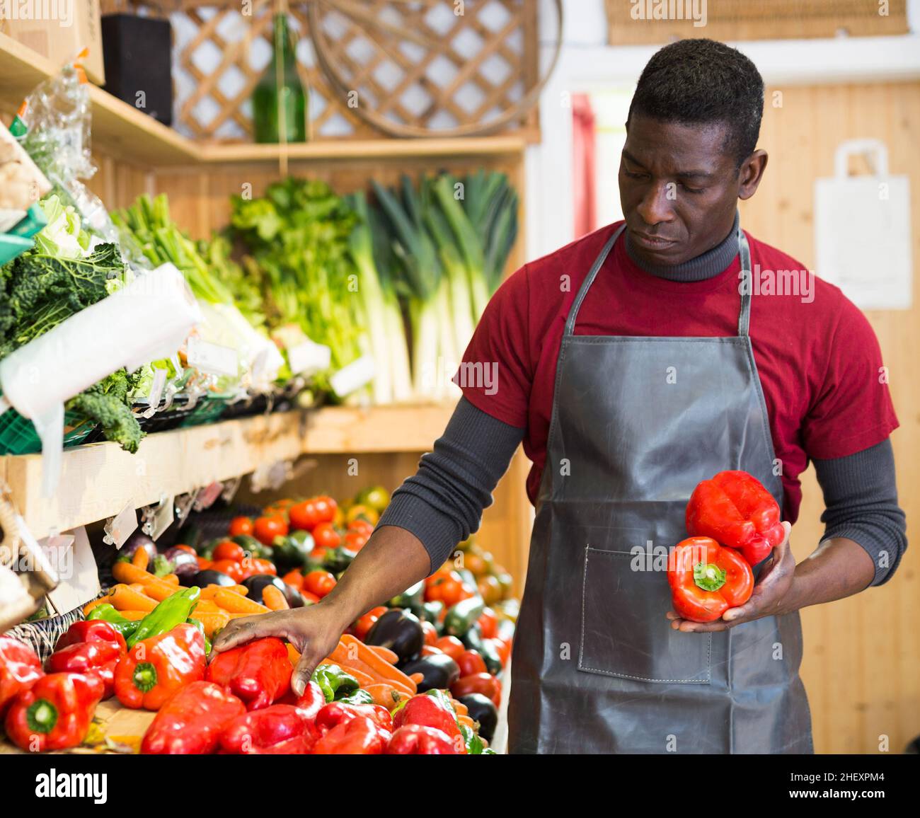 Man putting fruits and vegetables on market showcase Stock Photo - Alamy