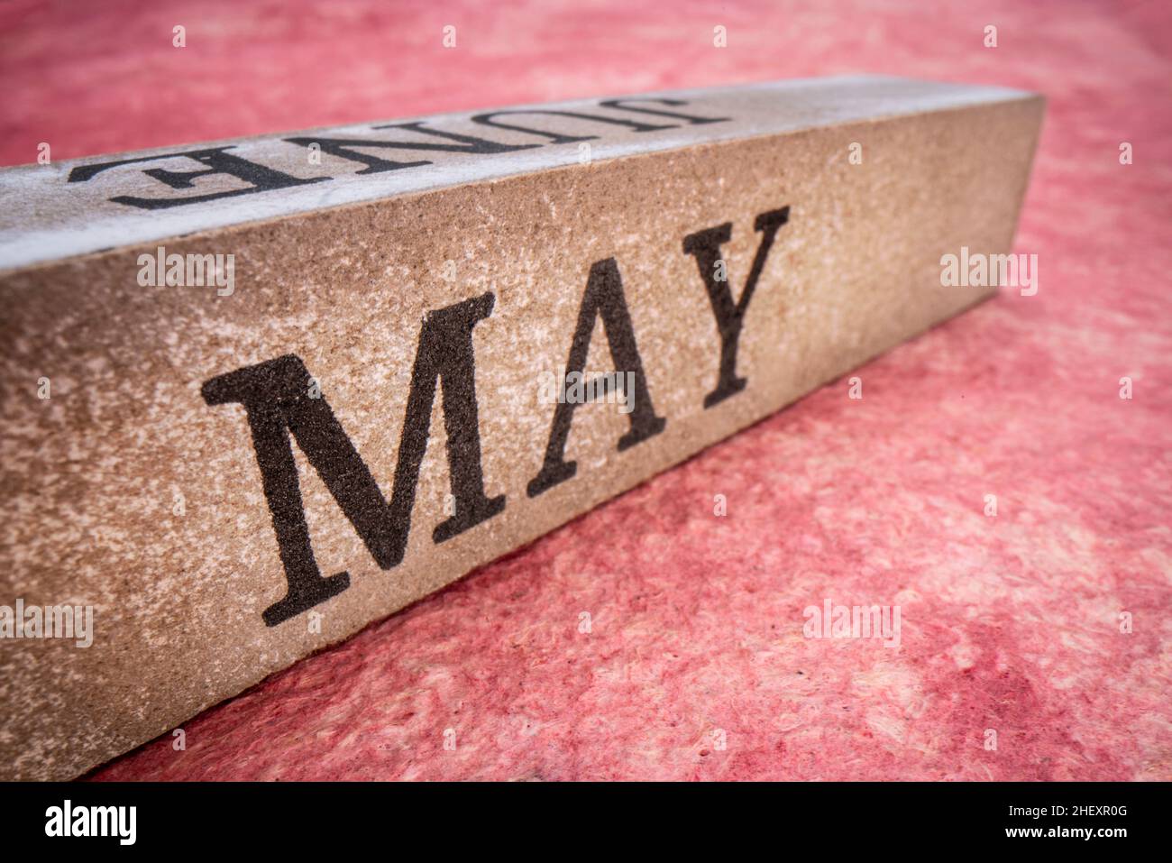 May text on grunge wooden block against handmade textured paper ...