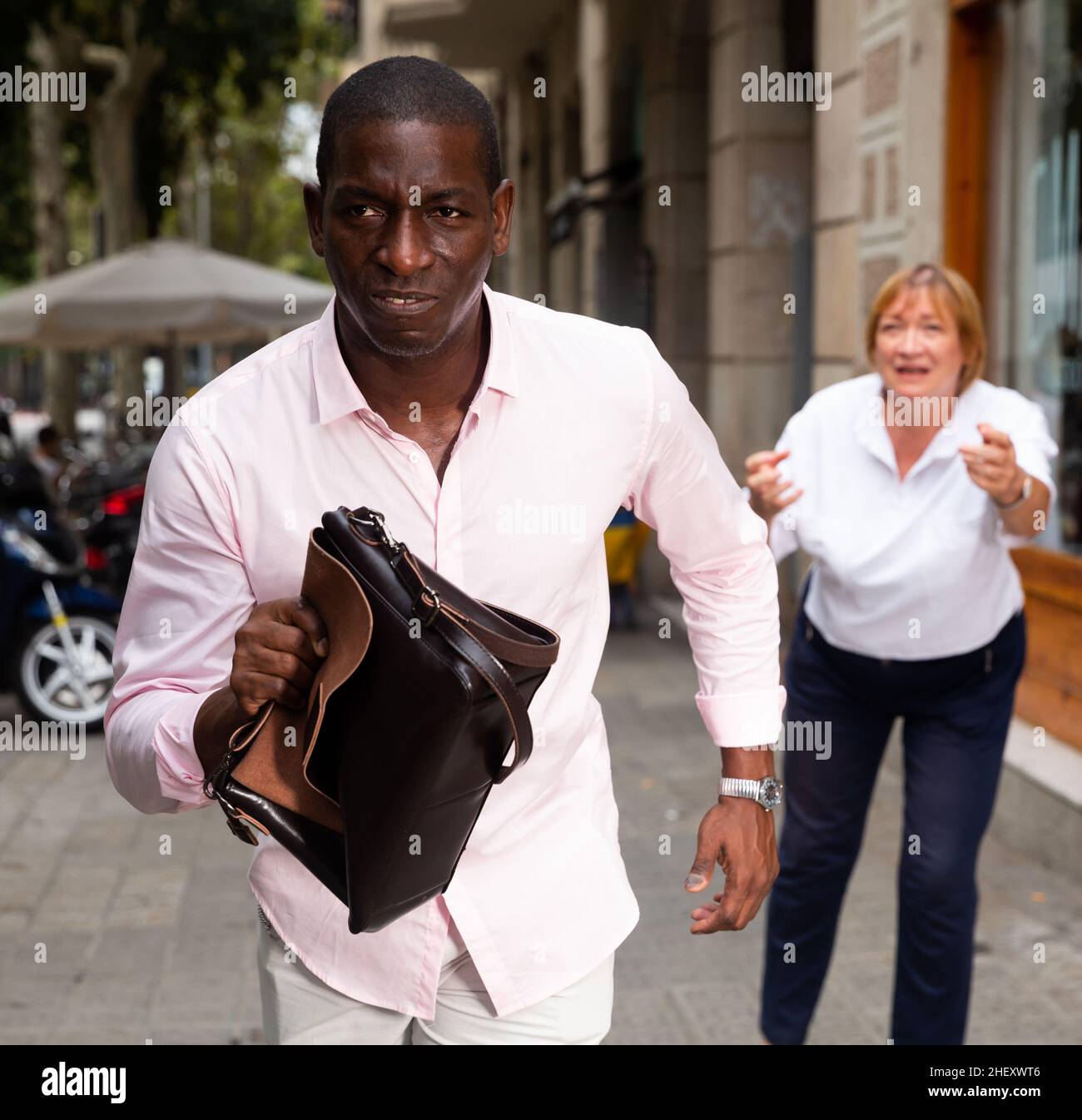 Street thief running away after stealing handbag from woman Stock Photo ...