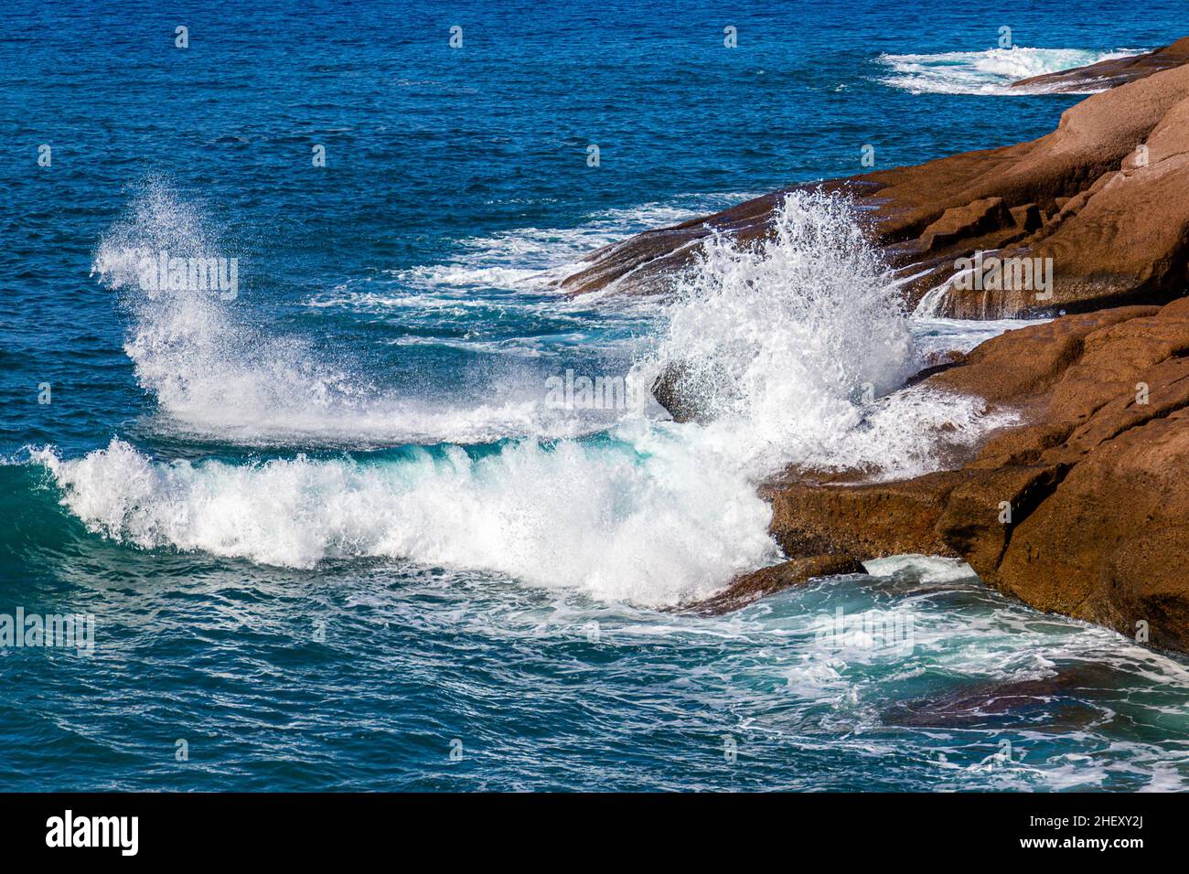 The waves of the Atlantic Ocean crash on rocks with splashes in ...
