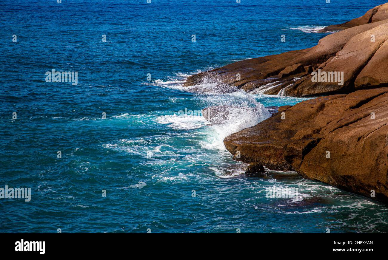 The waves of the Atlantic Ocean crash on rocks with splashes in ...