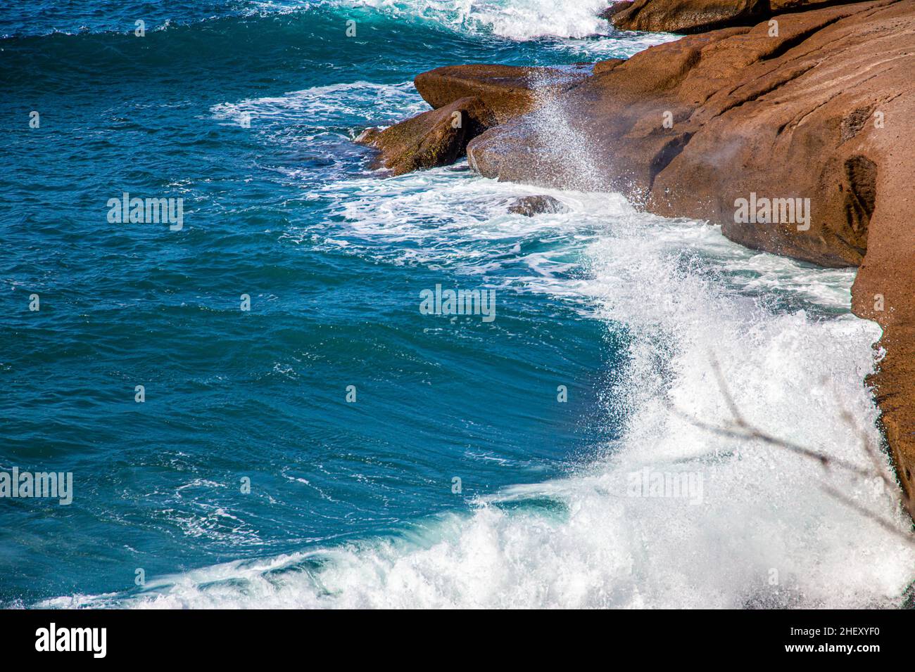 The waves of the Atlantic Ocean crash on rocks with splashes in ...