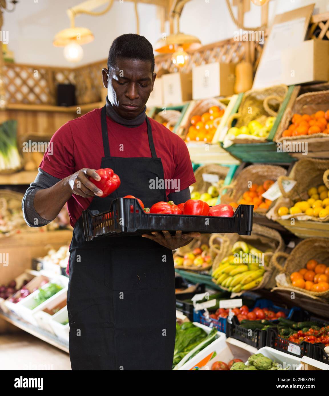 Salesman holding box with red peppers Stock Photo - Alamy