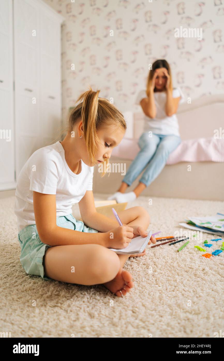 Vertical shot of primary girl child writing homework in copybook ...