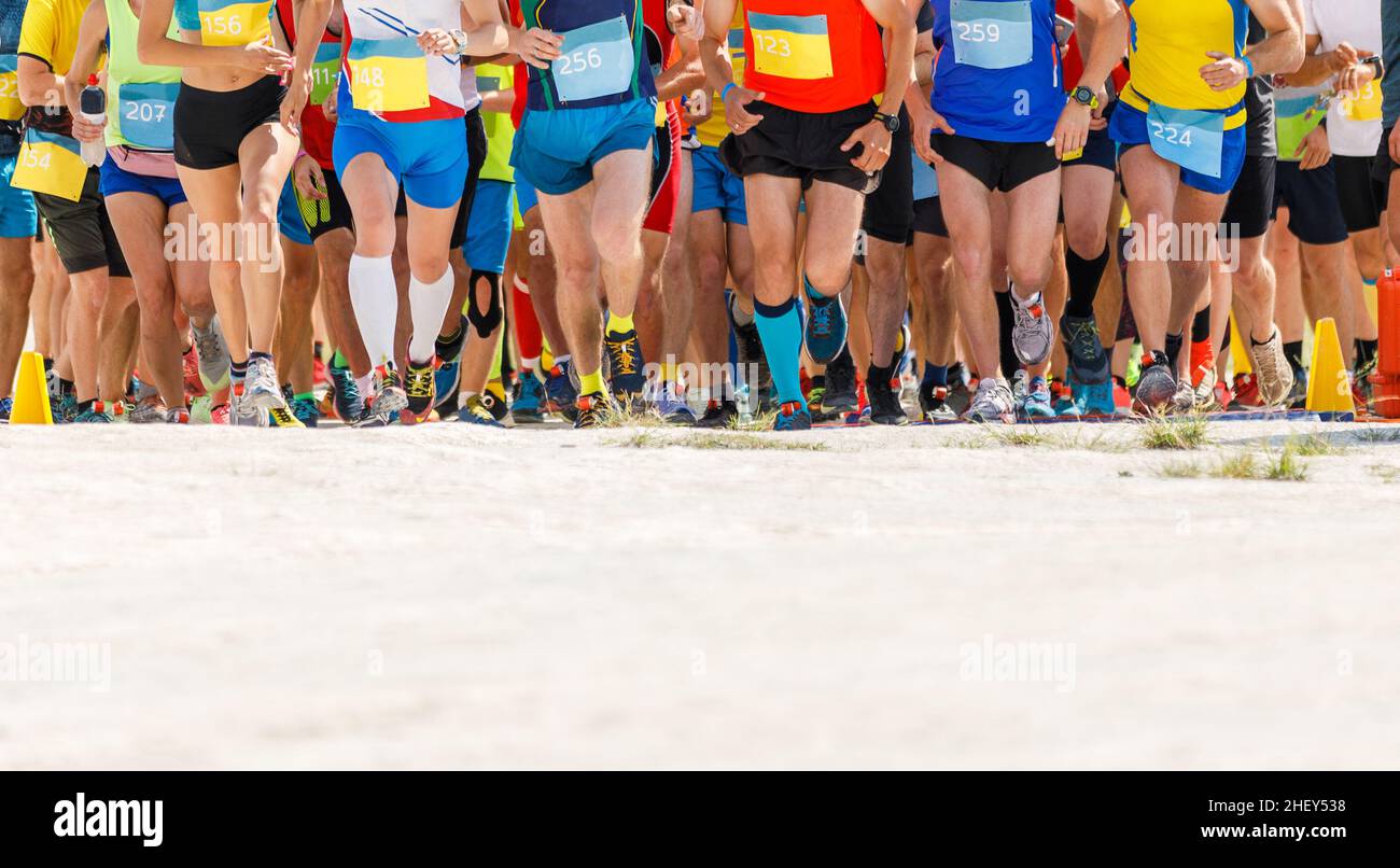 Large group of sportsmen starting running contest at desert Stock Photo ...