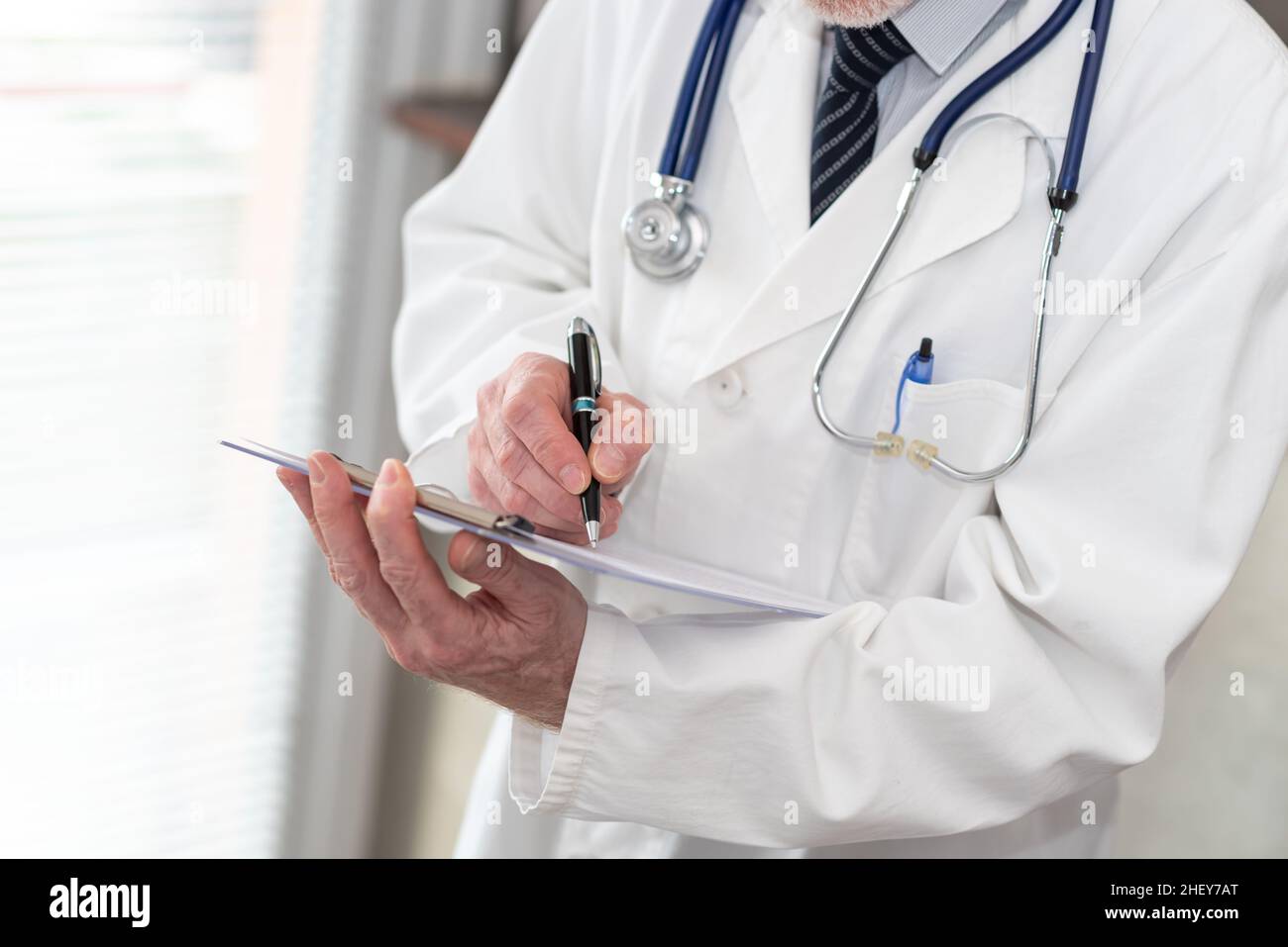 Doctor taking notes on clipboard in medical office Stock Photo - Alamy