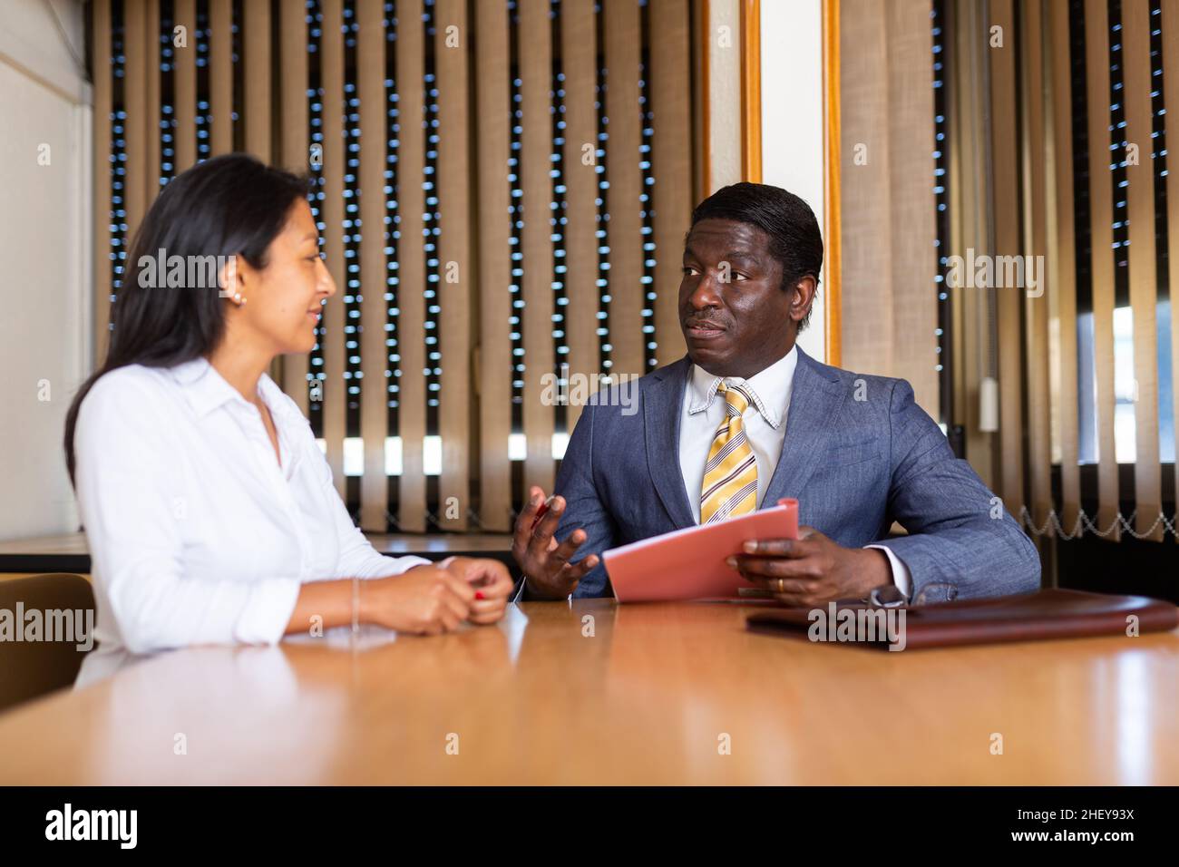 African american businessman discussing partnership documents with female partner Stock Photo ...