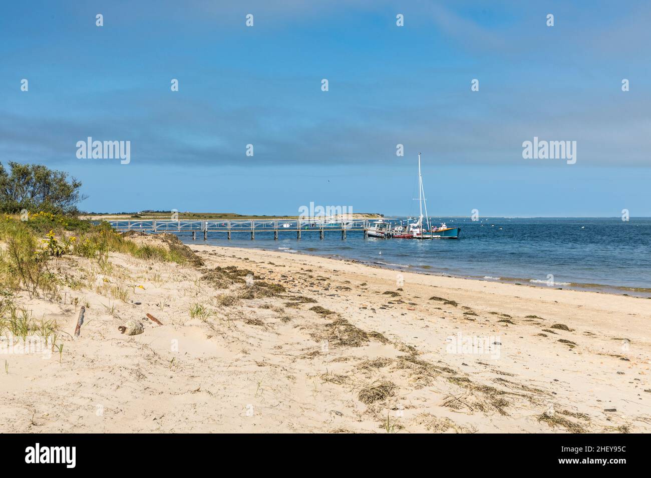 scenic beach at island Cape Cod with pier and sailing boat at Chatham ...