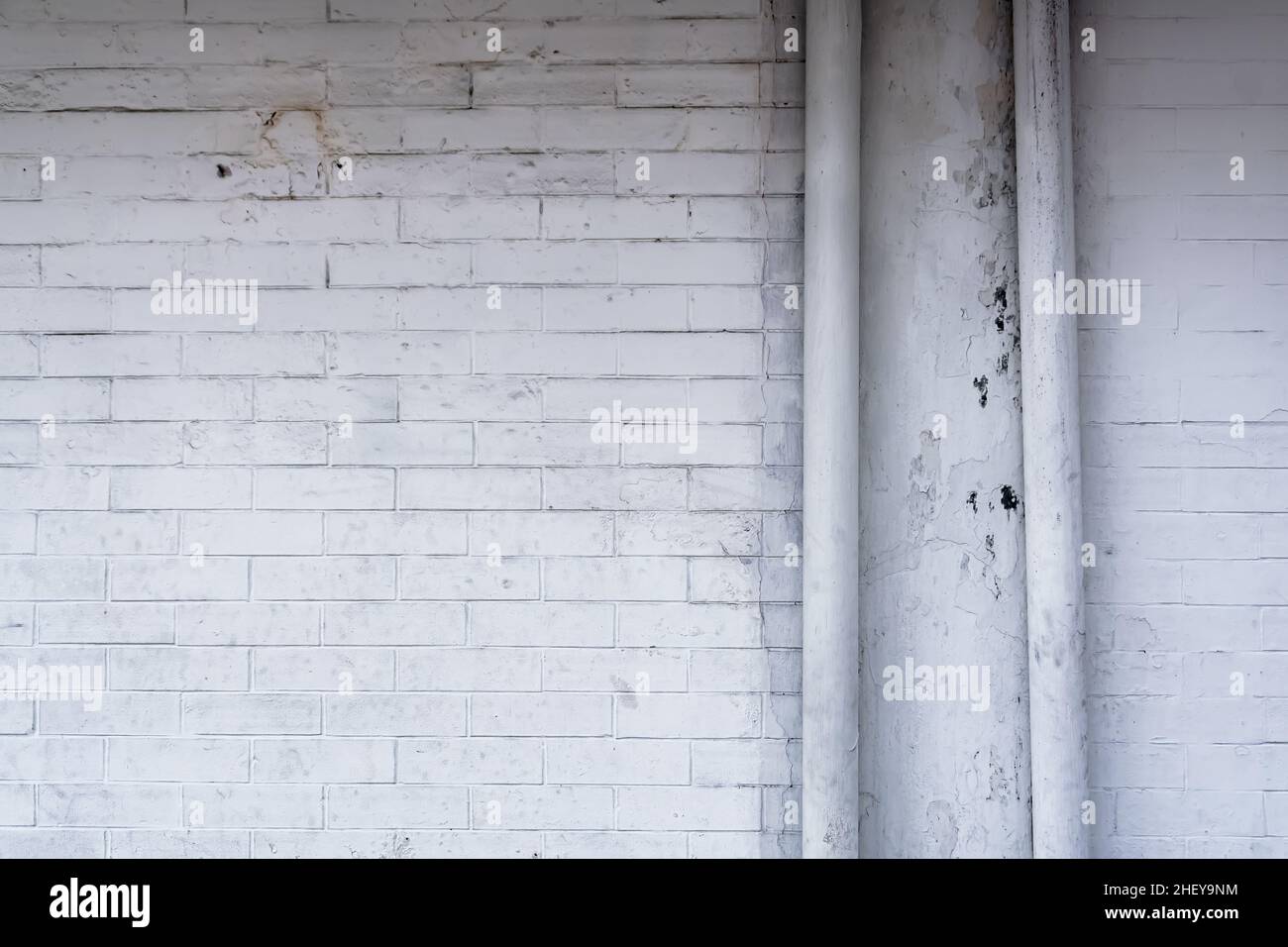 two of water pipes on the vintage rough white wall brick texture ...