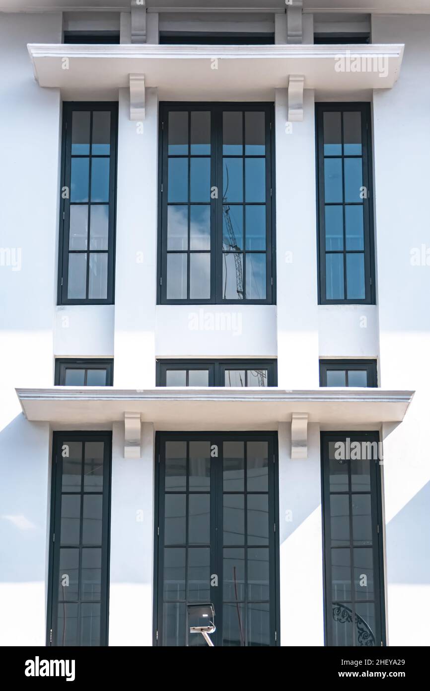 line of black vintage and old square window on the white colonial ...