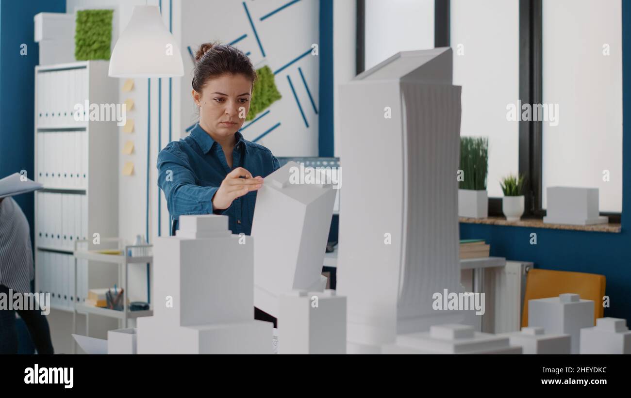 Portrait of architect looking at building model and maquette to plan ...