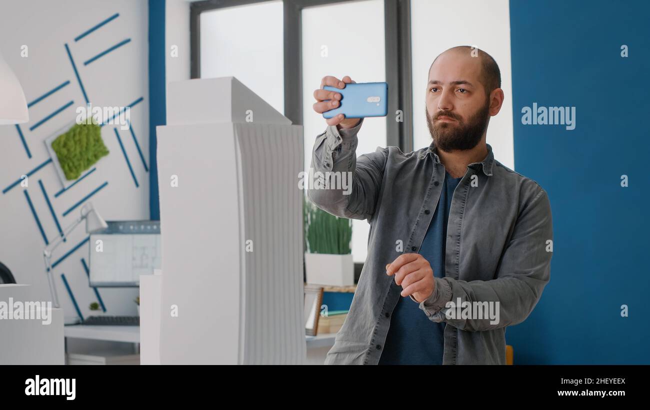 Close up of man working on architecture project with mobile phone to ...