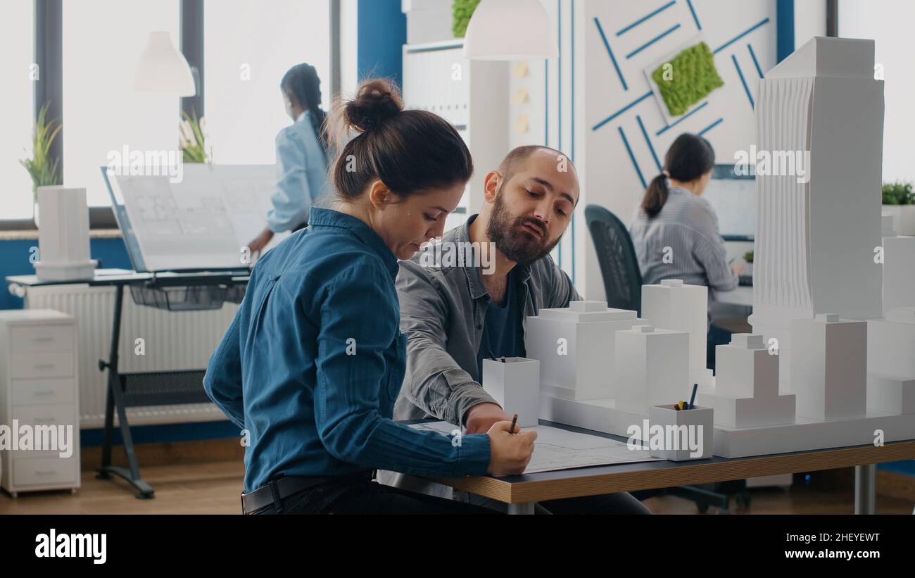 Colleagues doing teamwork to design construction layout with building ...